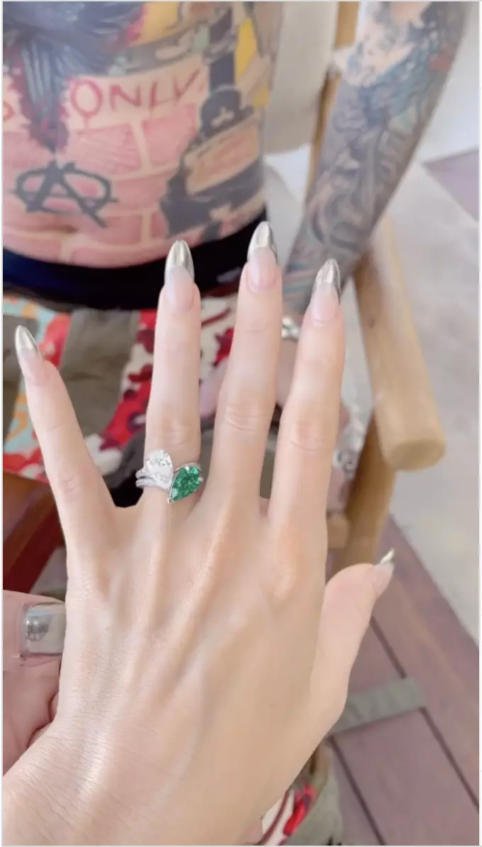 screenshot ng kamay ni megan fox na may silvertipped french manicure at twostone engagement ring