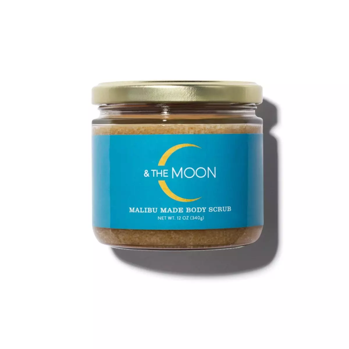 Tub tal-ħġieġ ta 'body scrub b'tikketta blu u għatu tad-deheb fuq sfond abjad