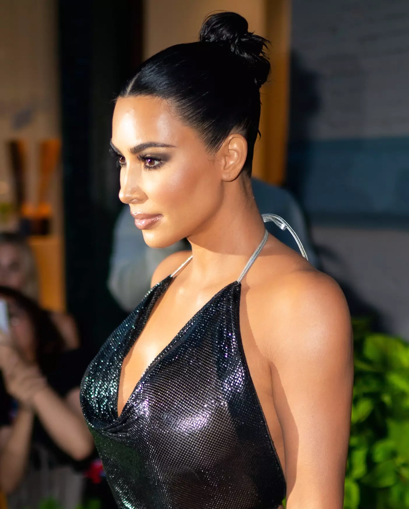 Kim Kardashian ma na sobie wysoki kok i czarny top bez ramiączek