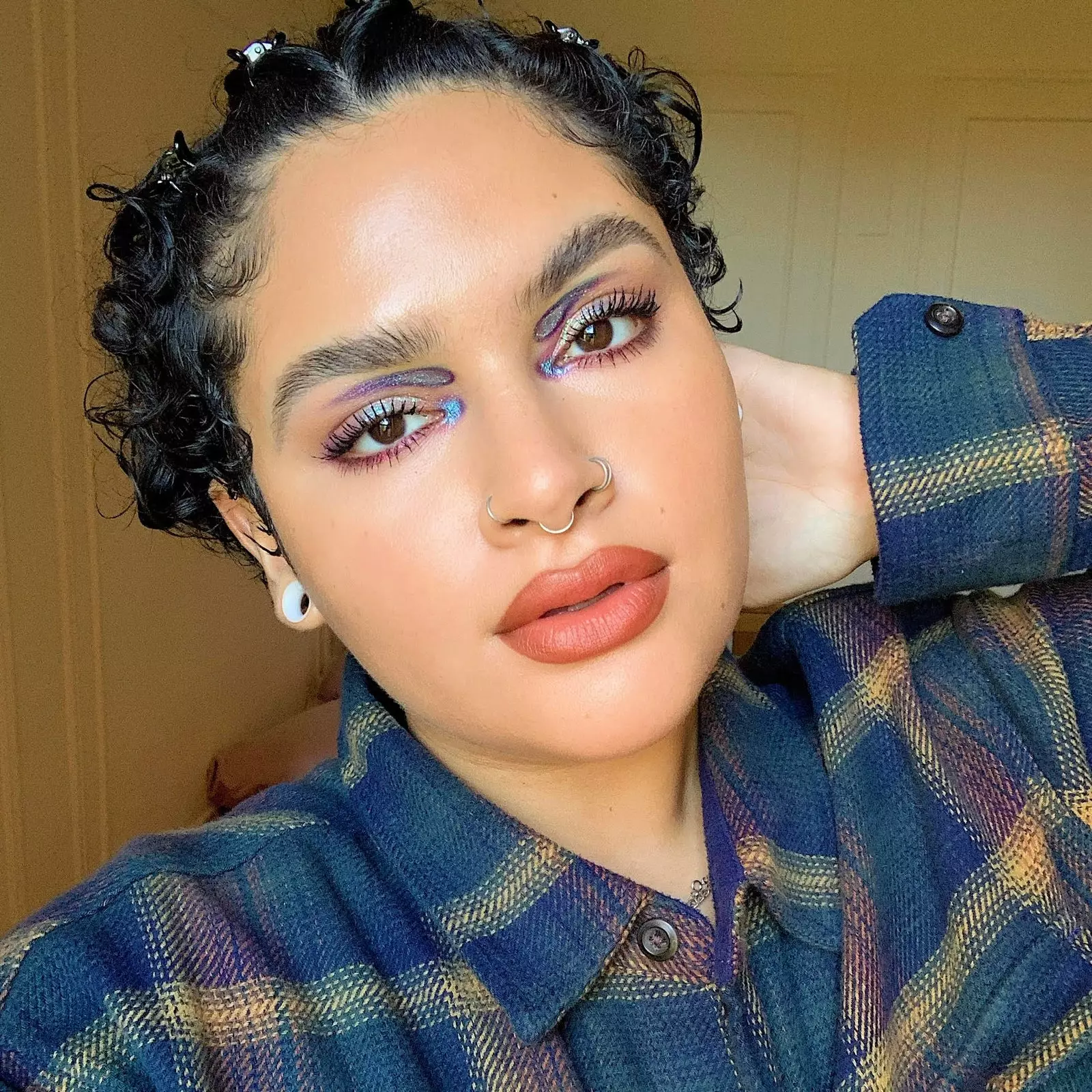 selfie tina influencer non-binér karolscorner ngagem makeup panon biru sareng pink grafis, biwir karang jero sareng kotak-kotak...