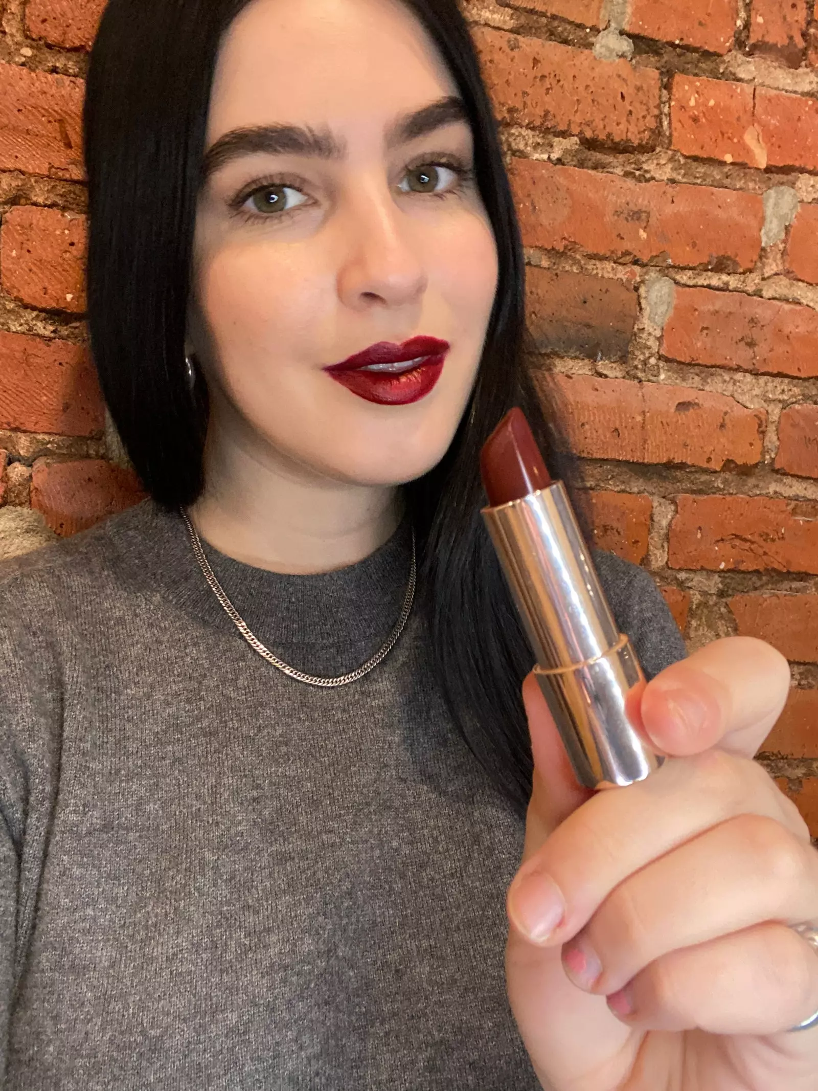 A editora da Allure, Taylore Glynn, tirando uma selfie usando os batons recarregáveis Fenty Beauty Fenty Icon.