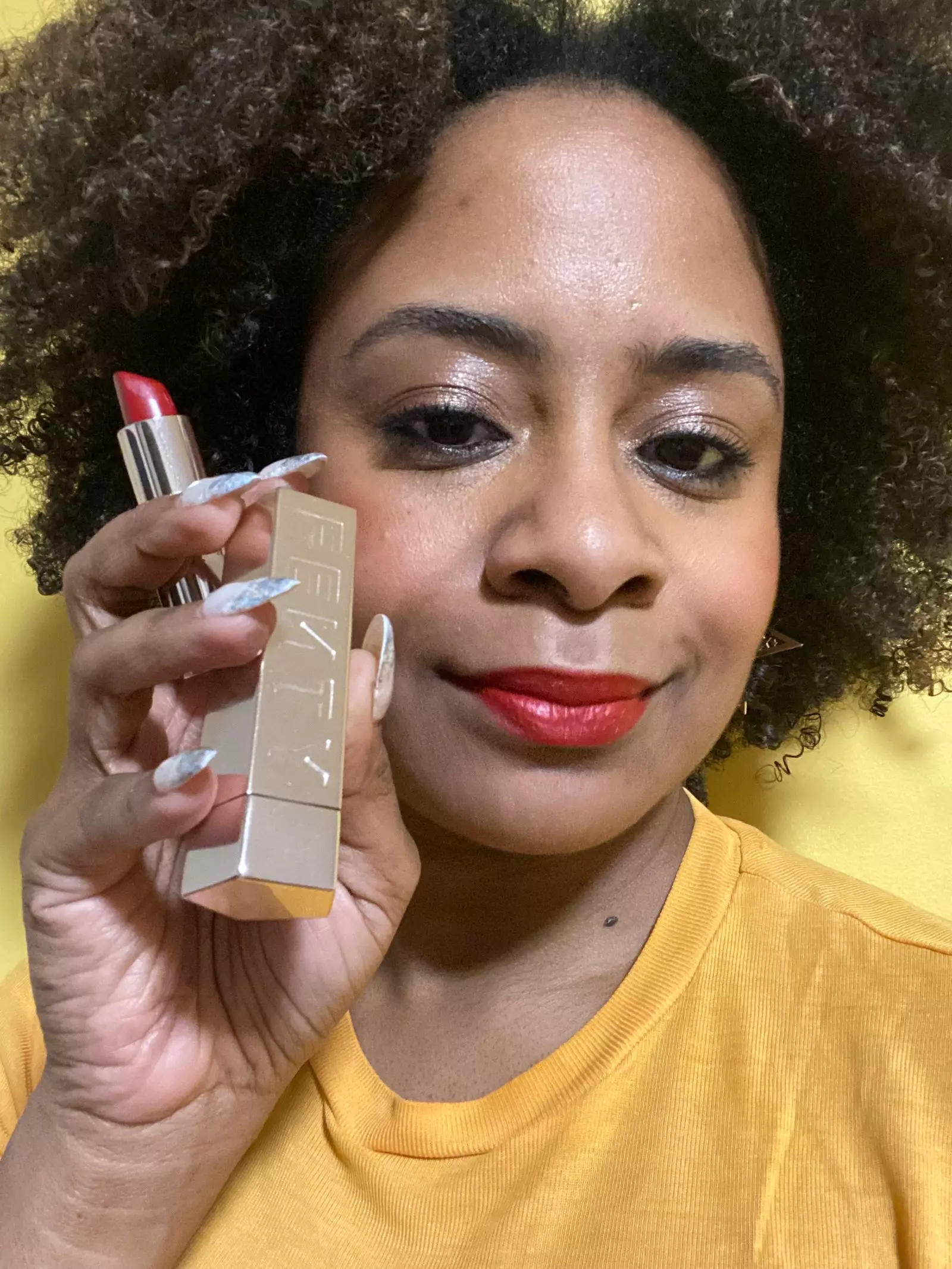 A editora da Allure, Jihan Forbes, tirando uma selfie usando os batons recarregáveis Fenty Beauty Fenty Icon.