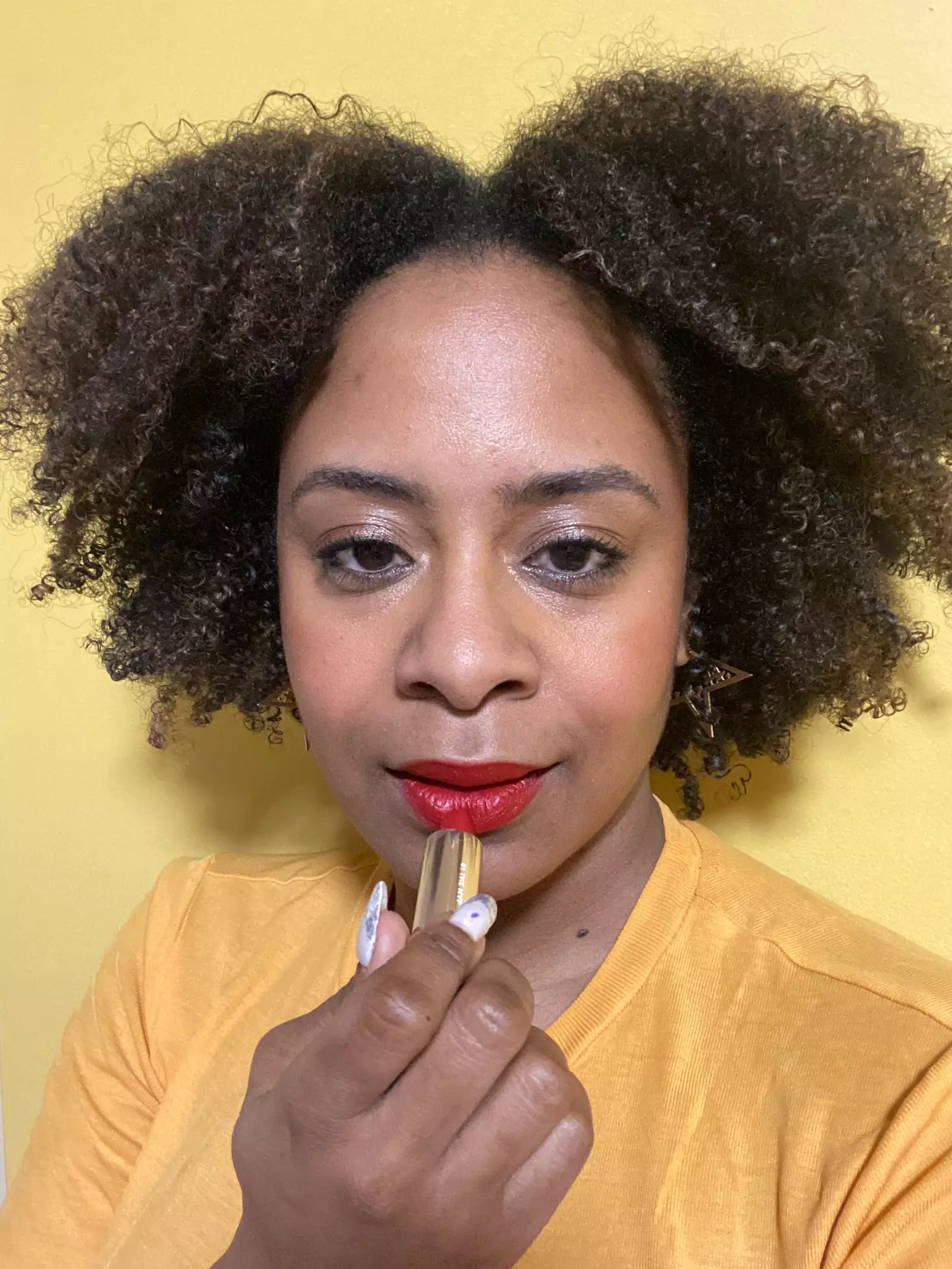 A editora da Allure, Jihan Forbes, tirando uma selfie usando os batons recarregáveis Fenty Beauty Fenty Icon.