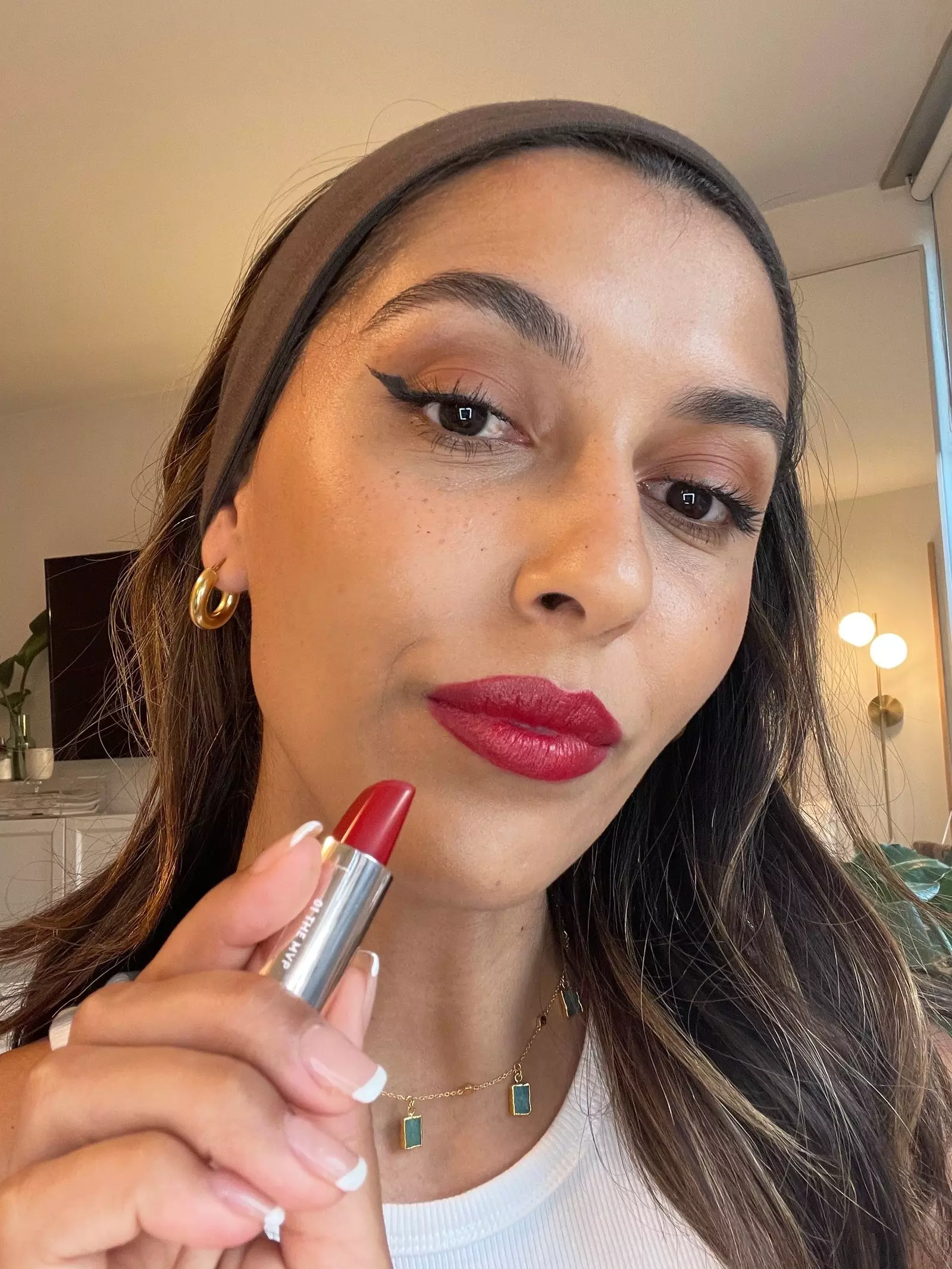 A editora da Allure, Talia Gutierrez, tirando uma selfie usando os batons recarregáveis Fenty Beauty Fenty Icon.