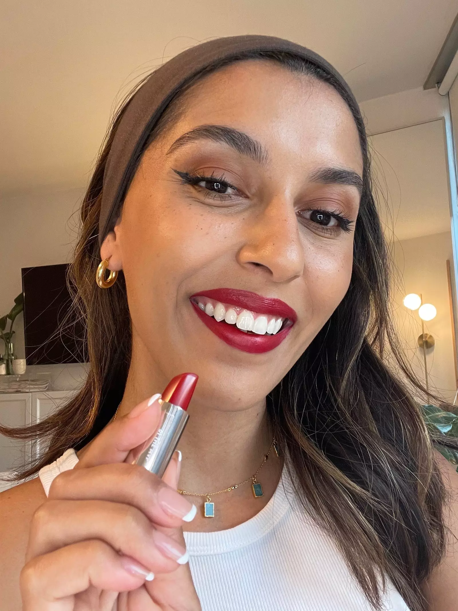 A editora da Allure, Talia Gutierrez, tirando uma selfie usando os batons recarregáveis Fenty Beauty Fenty Icon.