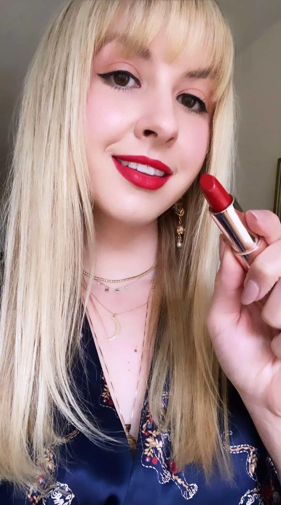 A editora de fascinación Paige Stables tomándose unha selfie usando batons recargables Fenty Beauty Fenty Icon.