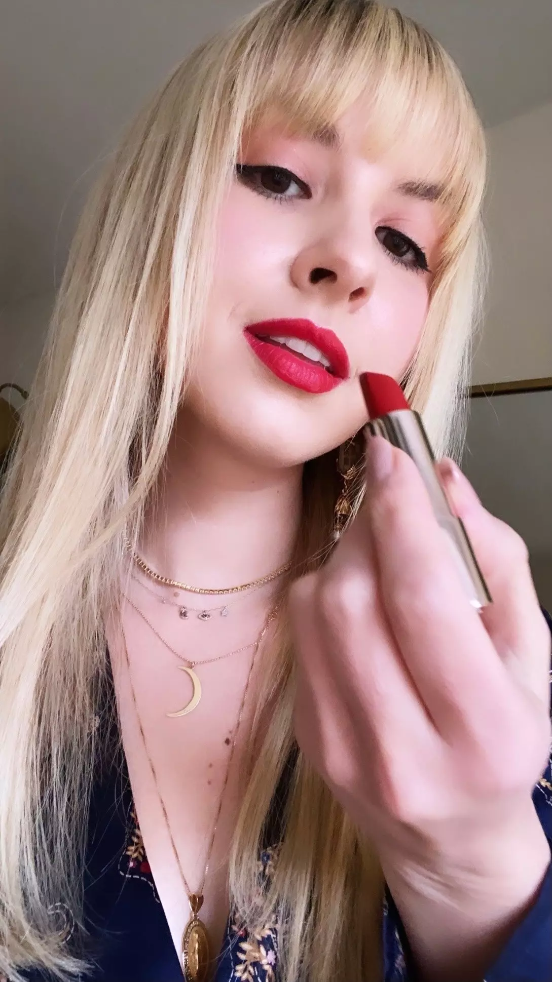 A editora de fascinación Paige Stables tomándose unha selfie usando batons recargables Fenty Beauty Fenty Icon.