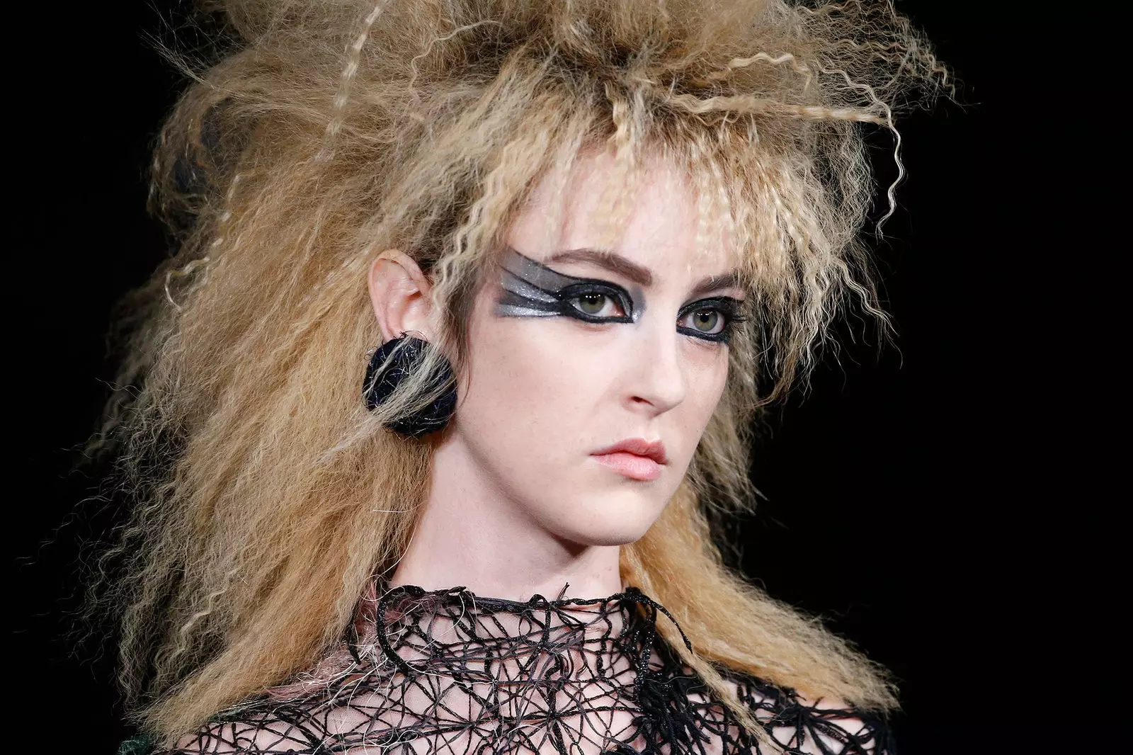 Paris Couture Week modèle Viktor Rolf portant un maquillage des yeux noir et argent avec de grands cheveux frisés