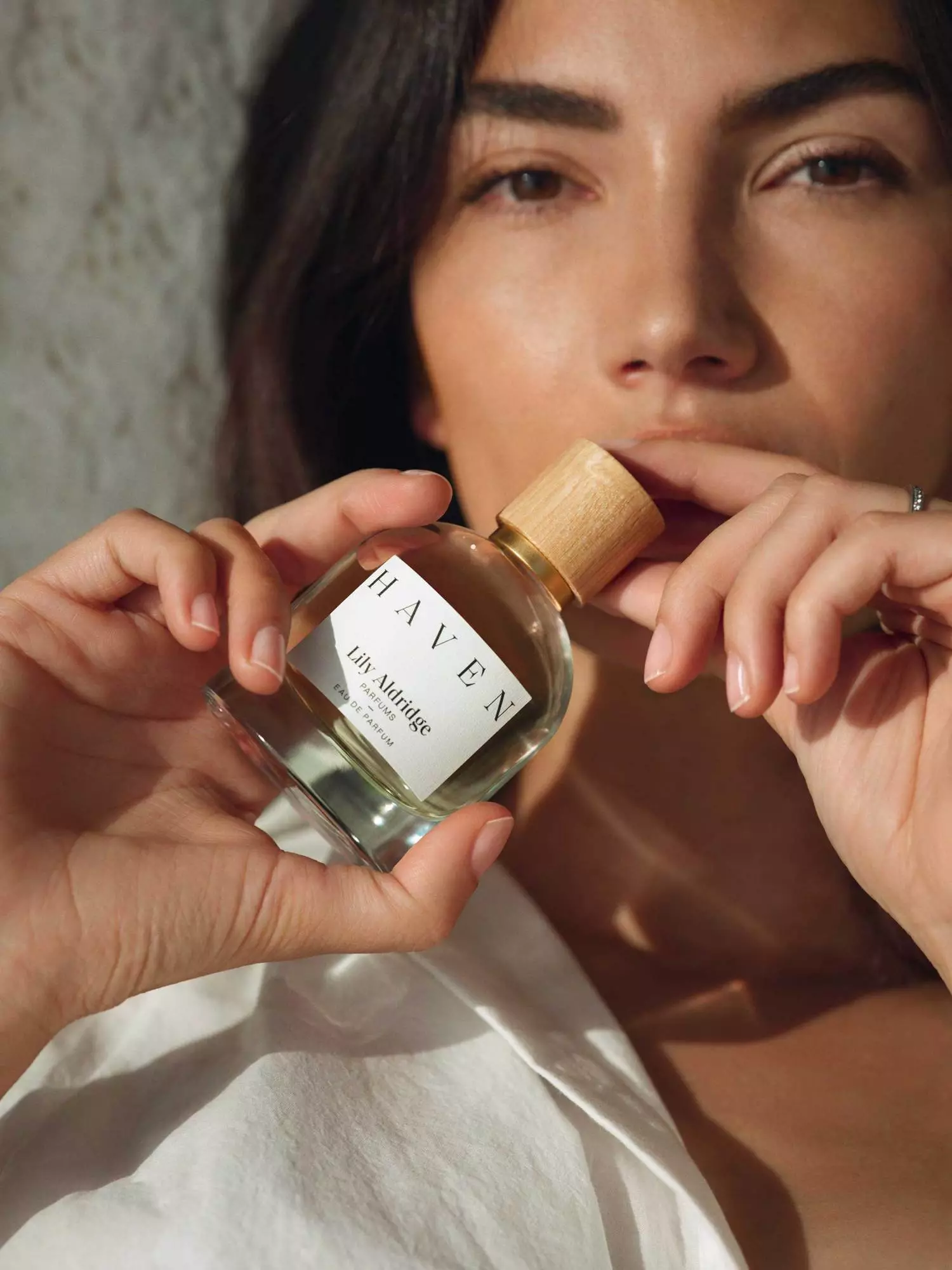 Lily Aldridge holder en flaske af sin Haven-parfume op